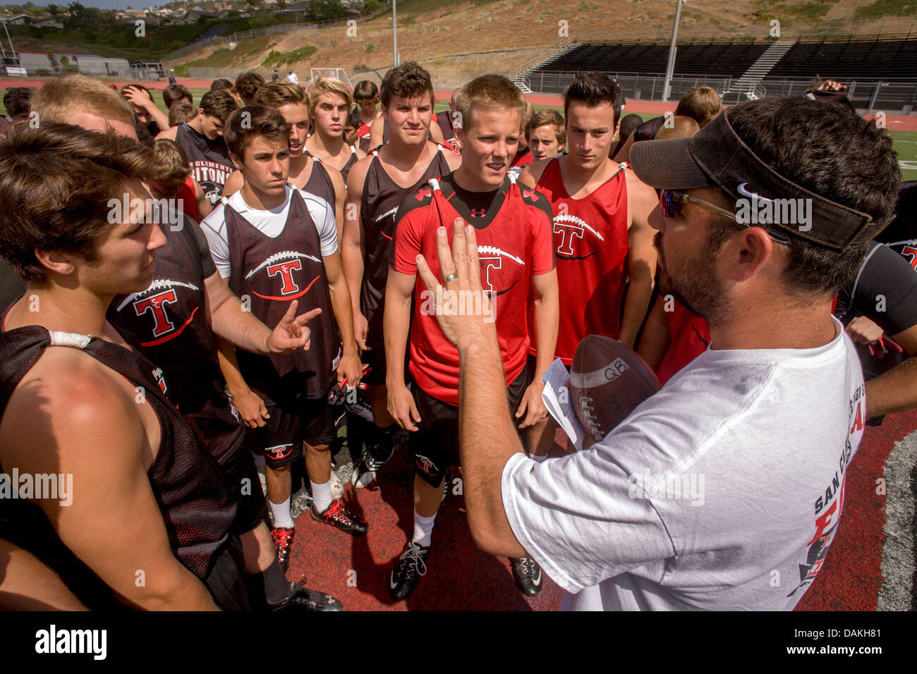 A high school coach gives a pep talk to his new team during spring ...