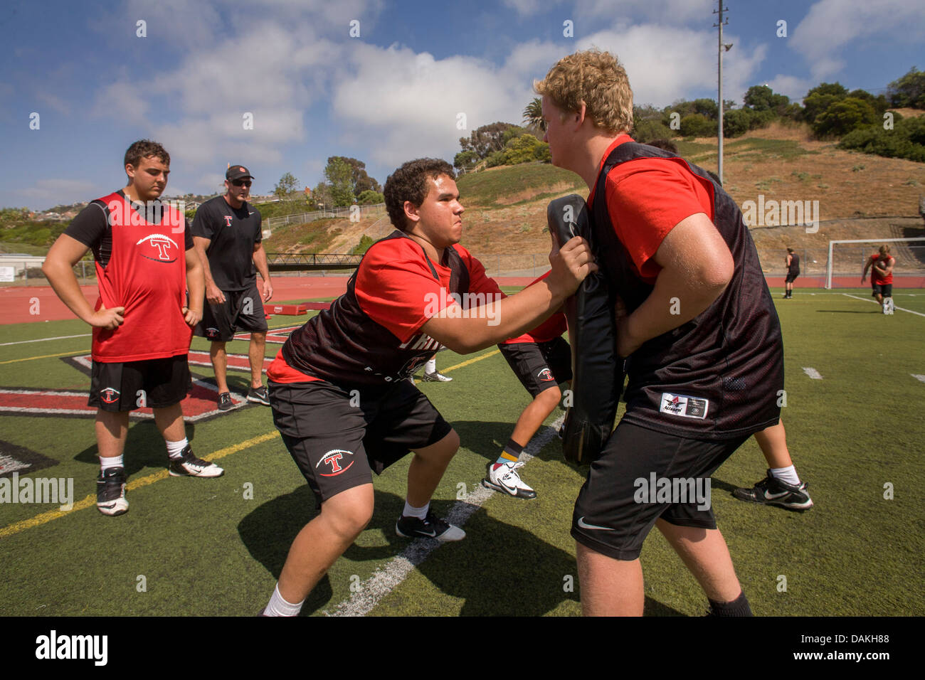 Using protective pads, multiethnic high school athletes practice ...