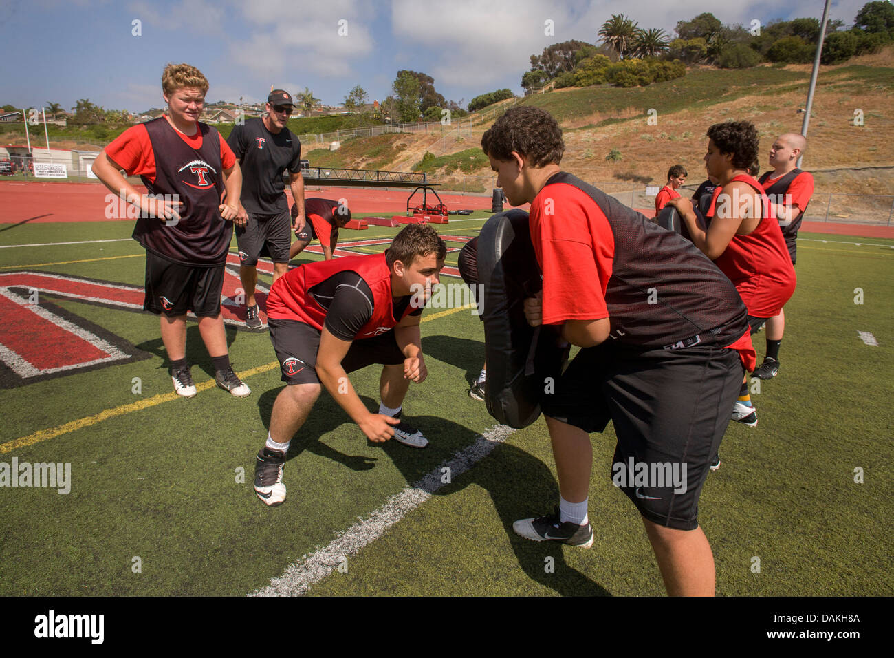 Using protective pads, multiethnic high school athletes practice ...