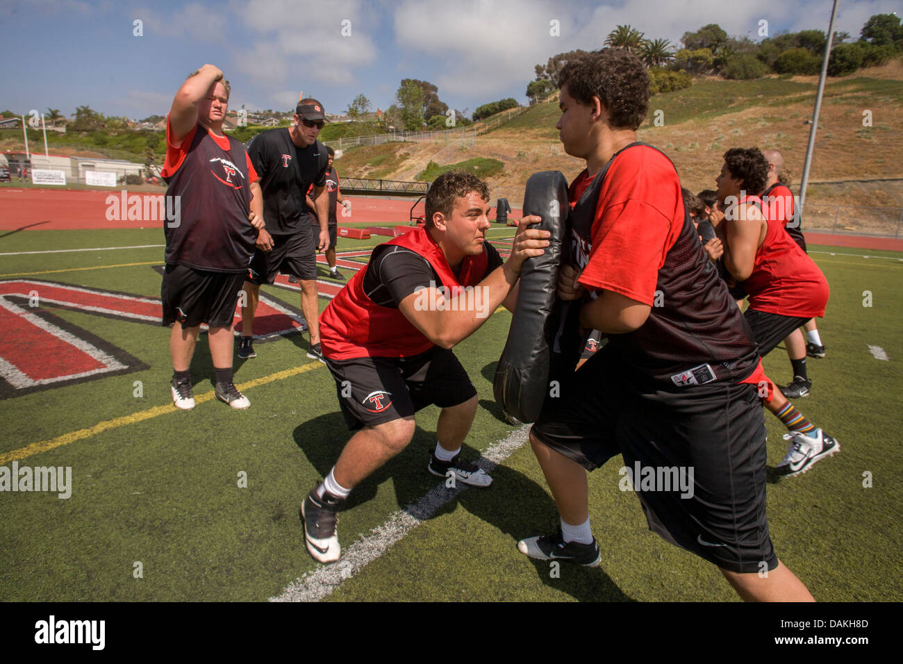 Using protective pads, multiethnic high school athletes practice ...