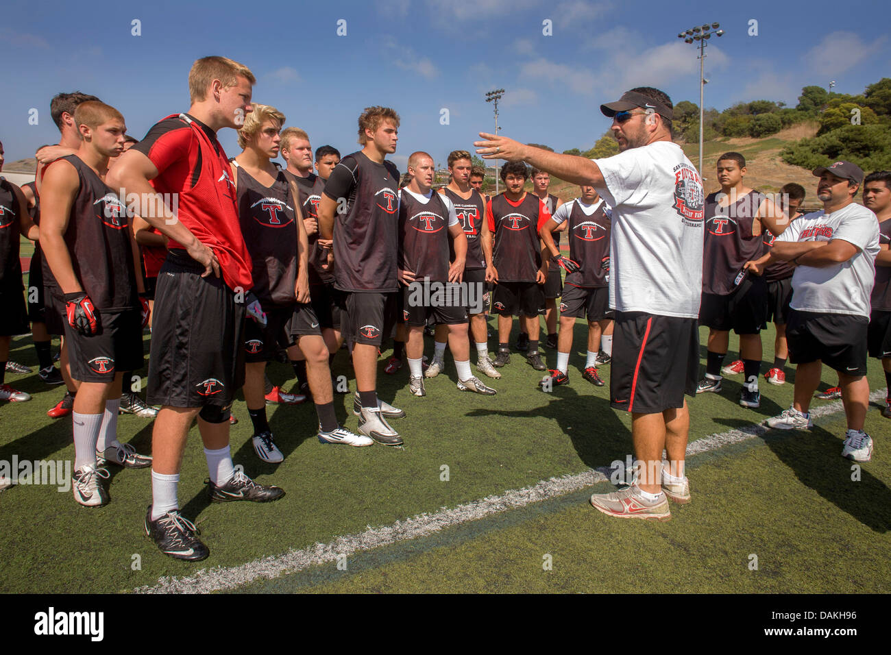 A high school coach gives a pep talk to his new team during spring ...