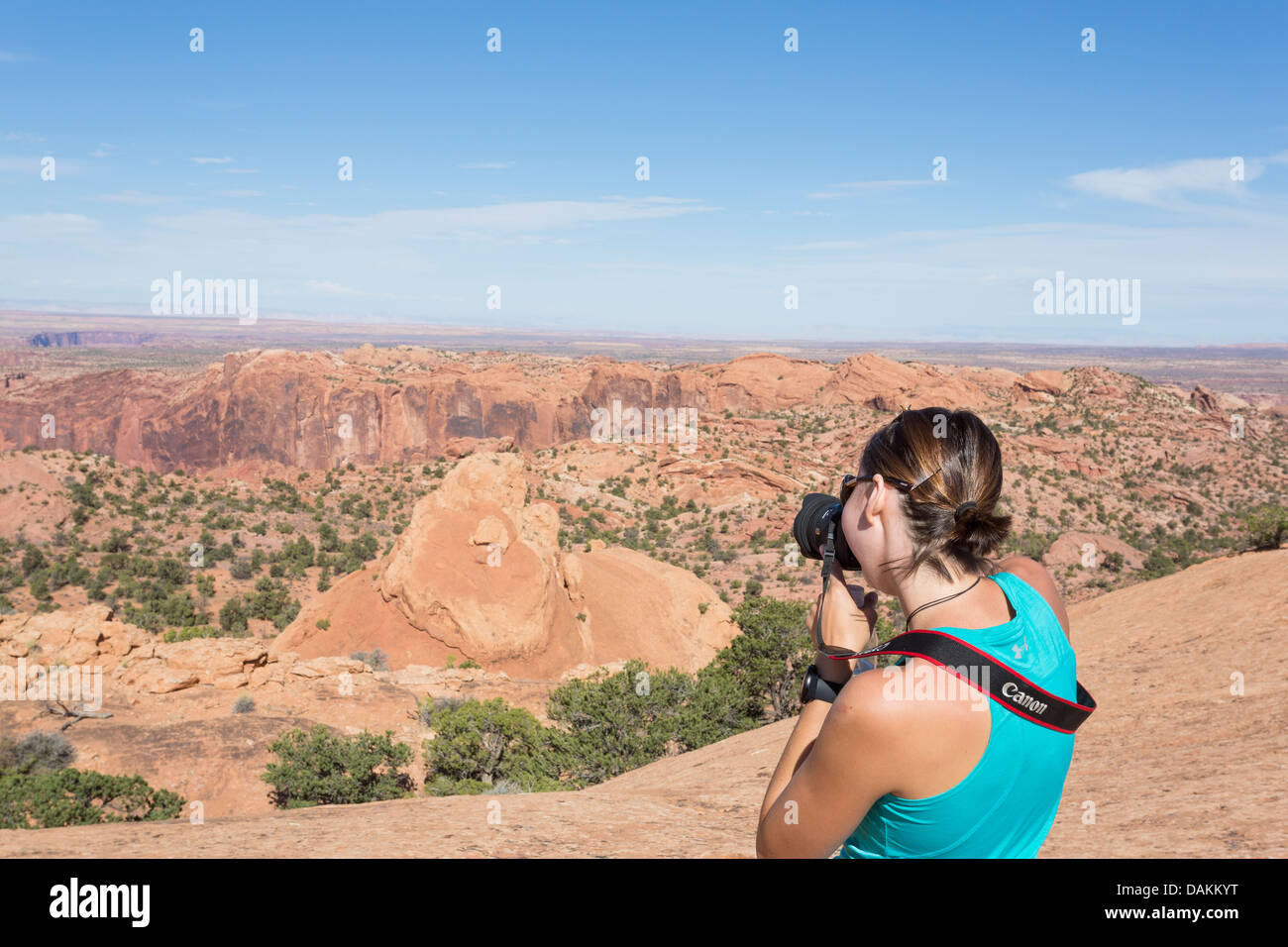 Young female photographer / tourist taking a picture of the rock ...