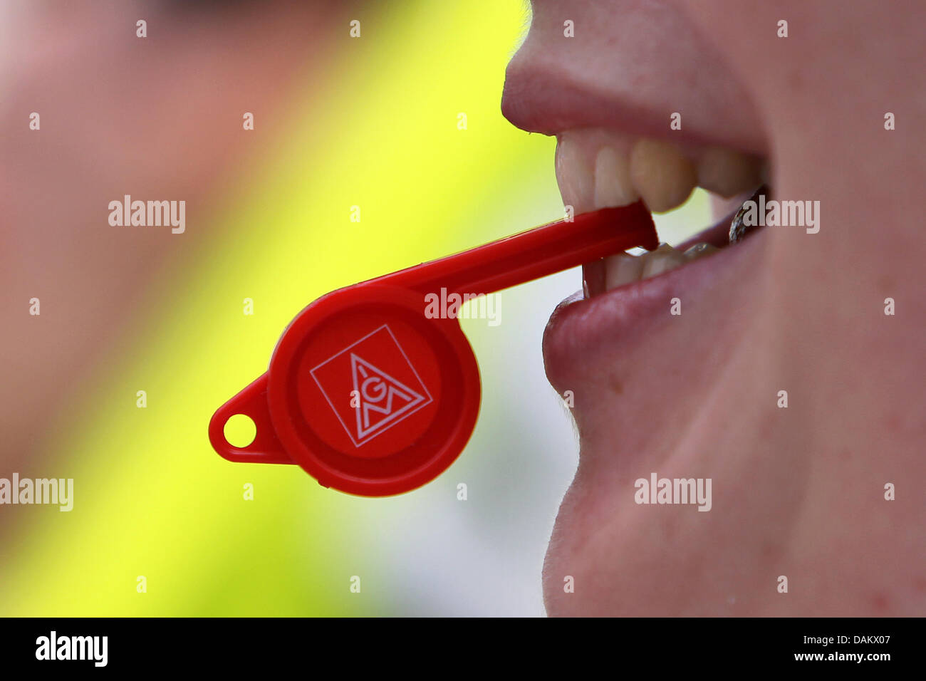 A participant holds a workers union whistle between her teeth during a ...