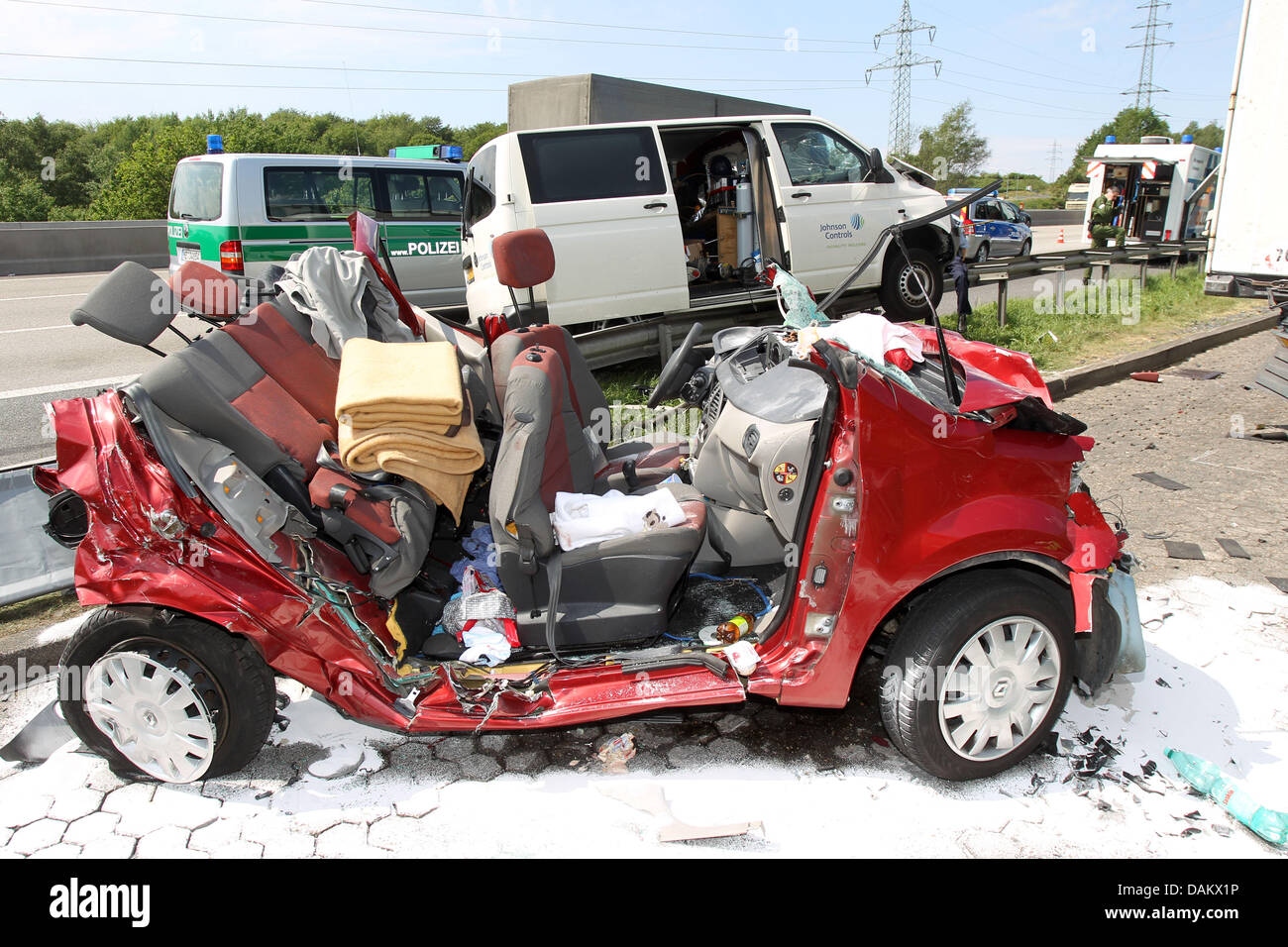 Police officers stand at the site of an accident, where a car, a small ...