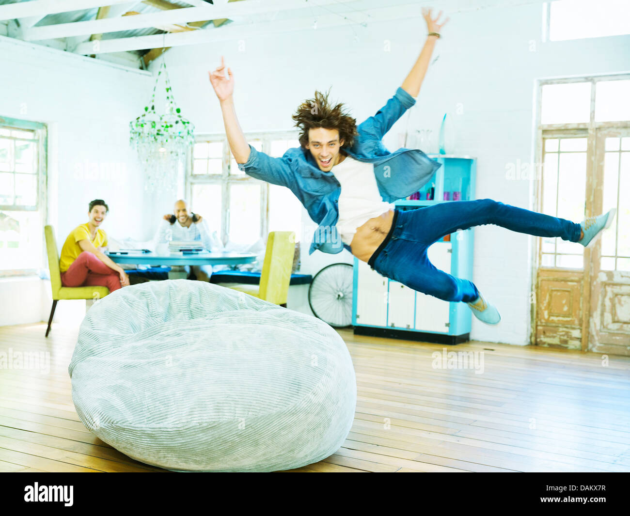 Man jumping into beanbag chair Stock Photo - Alamy