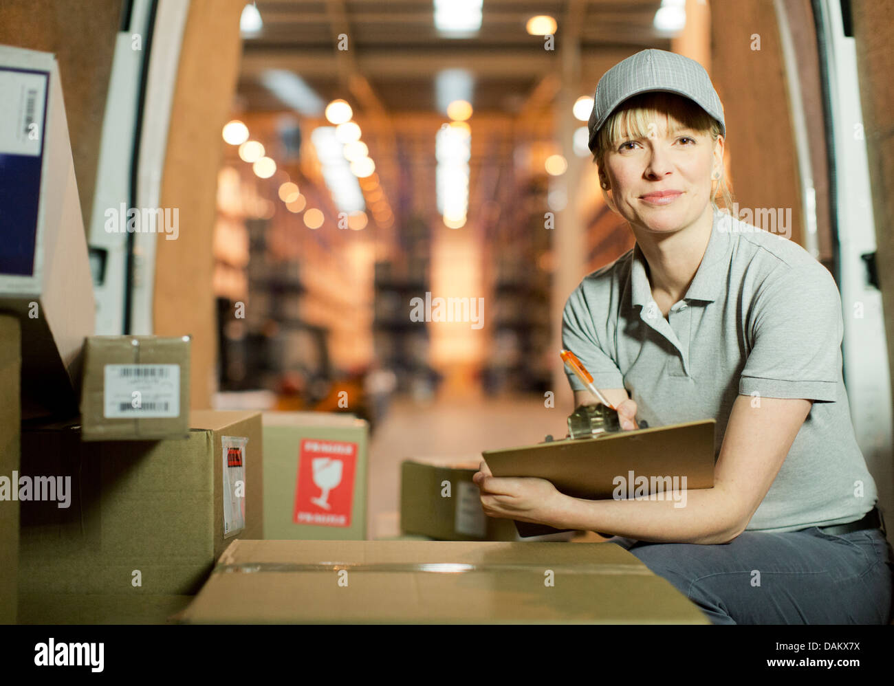 Delivery girl checking boxes in van Stock Photo - Alamy