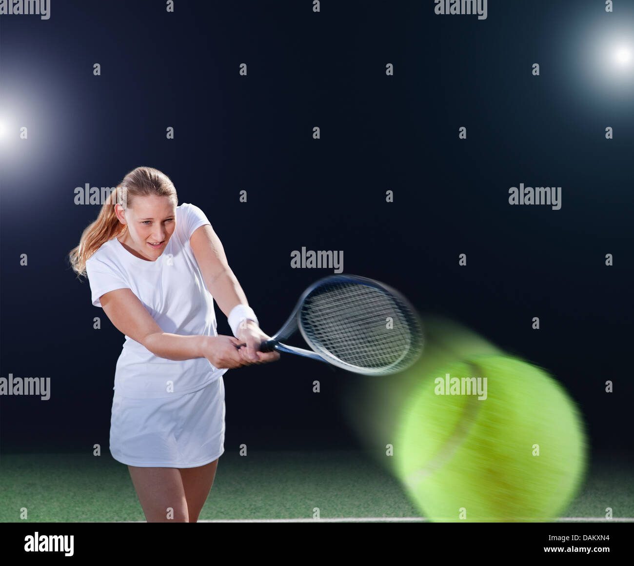 Tennis player hitting ball on court Stock Photo - Alamy