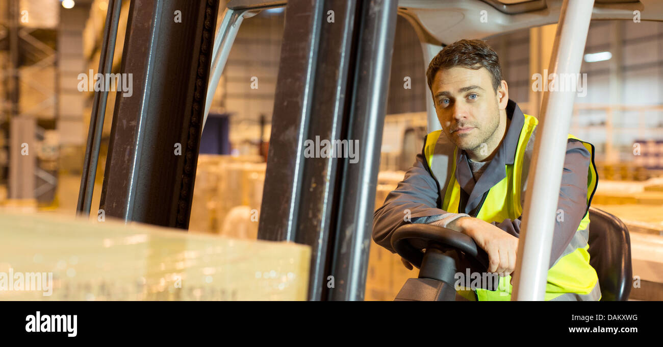 Worker operating machinery in warehouse Stock Photo - Alamy