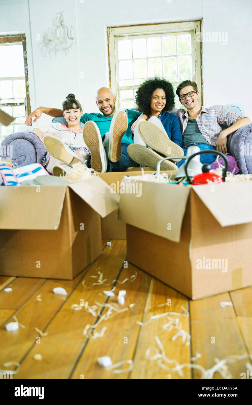 Friends relaxing in new home Stock Photo - Alamy