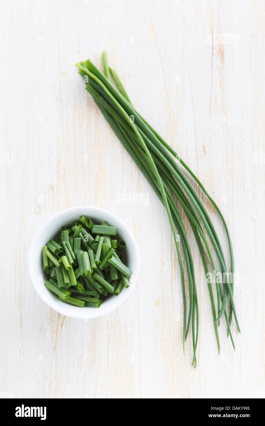 Bowl of chives on chopping board, close up Stock Photo - Alamy