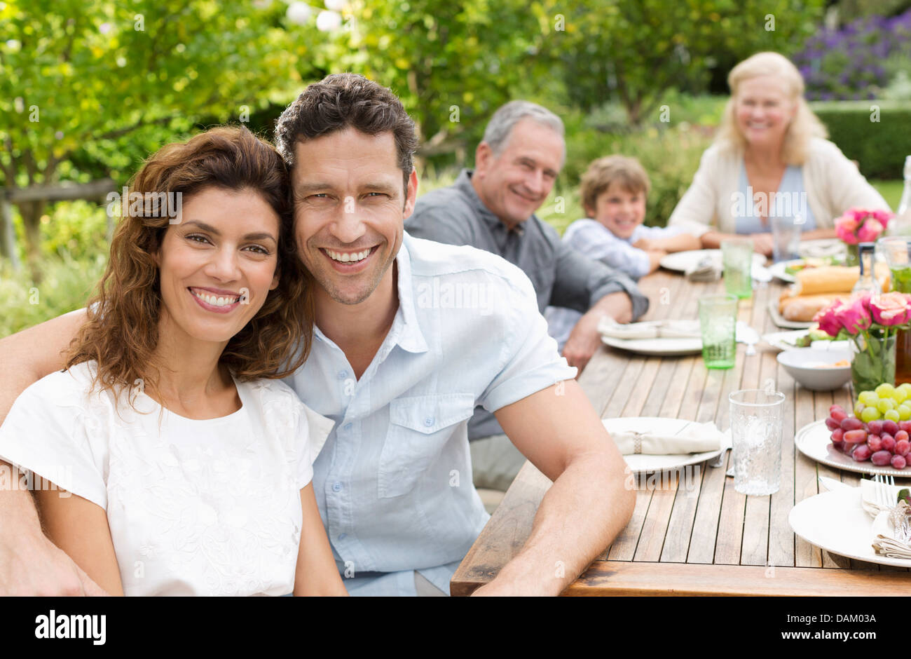 Smiling family sitting table hi-res stock photography and images - Alamy