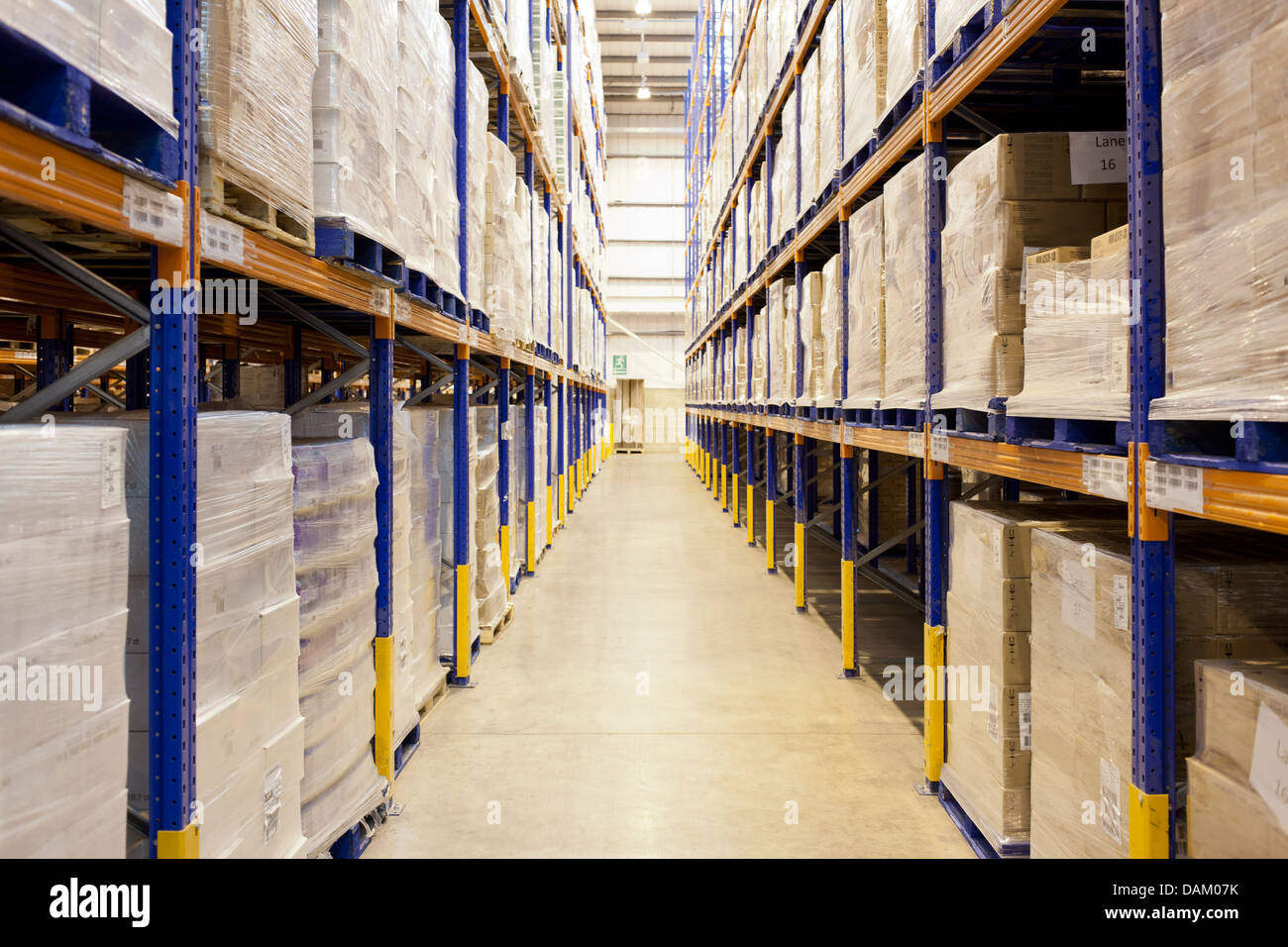 Stacks of boxes in aisle in warehouse Stock Photo - Alamy