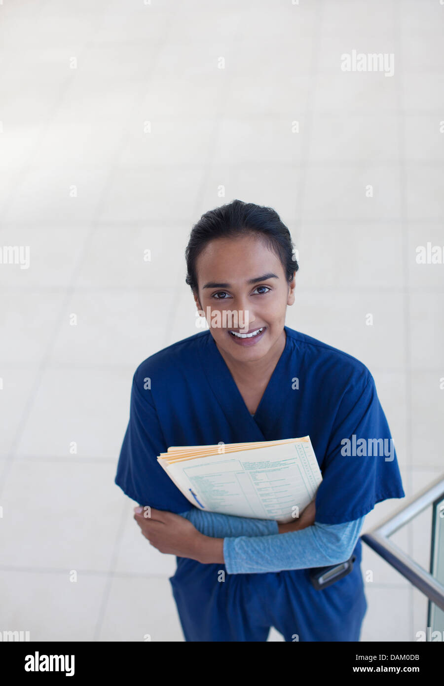 Nurse holding folders in hospital hallway Stock Photo - Alamy