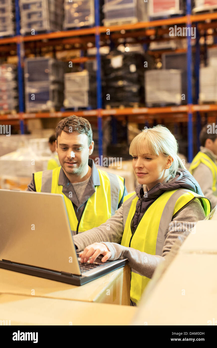 Workers using laptop in warehouse Stock Photo - Alamy