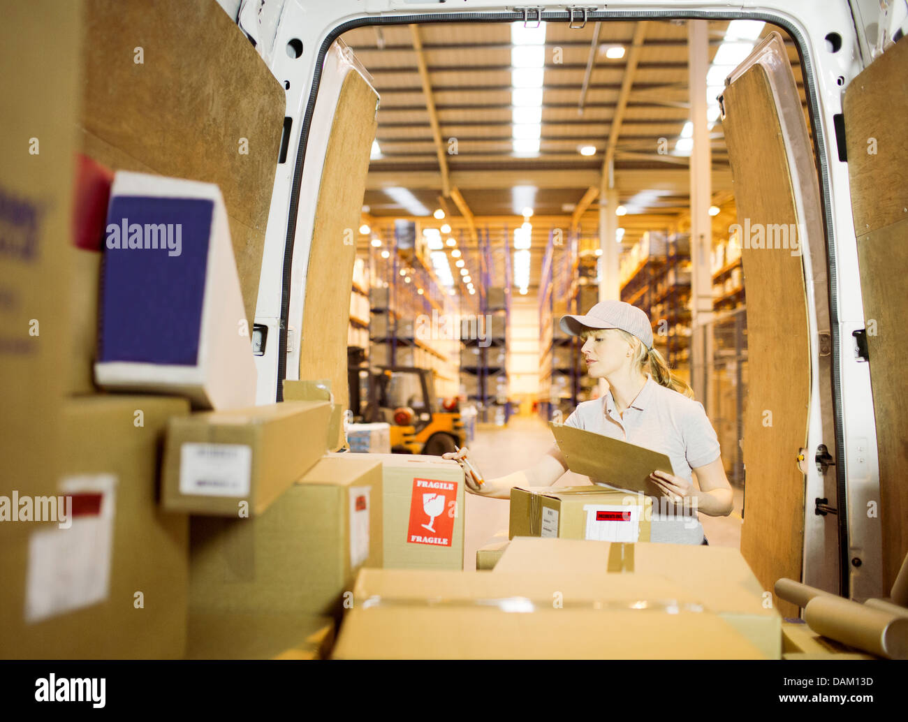Delivery girl checking boxes in van Stock Photo - Alamy