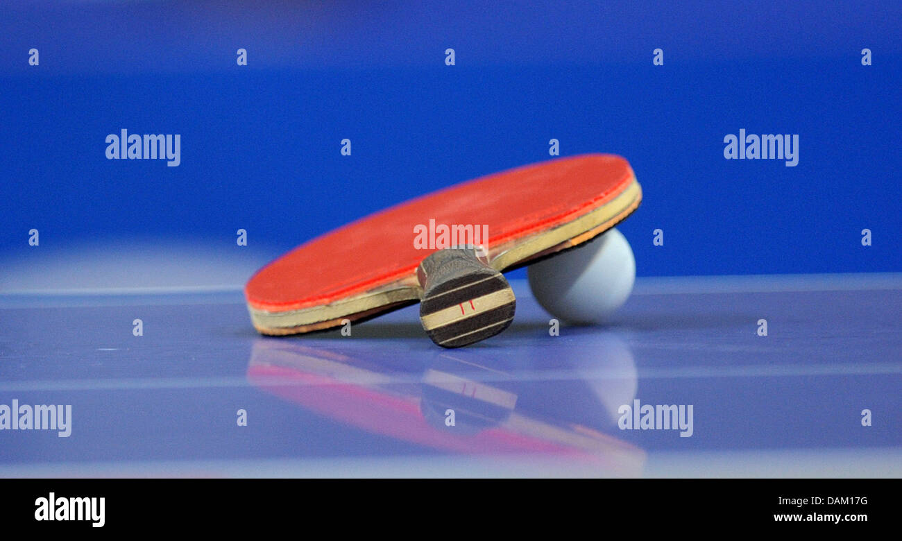 A table tennis bat and a ball lie on a table tennis table during a ...