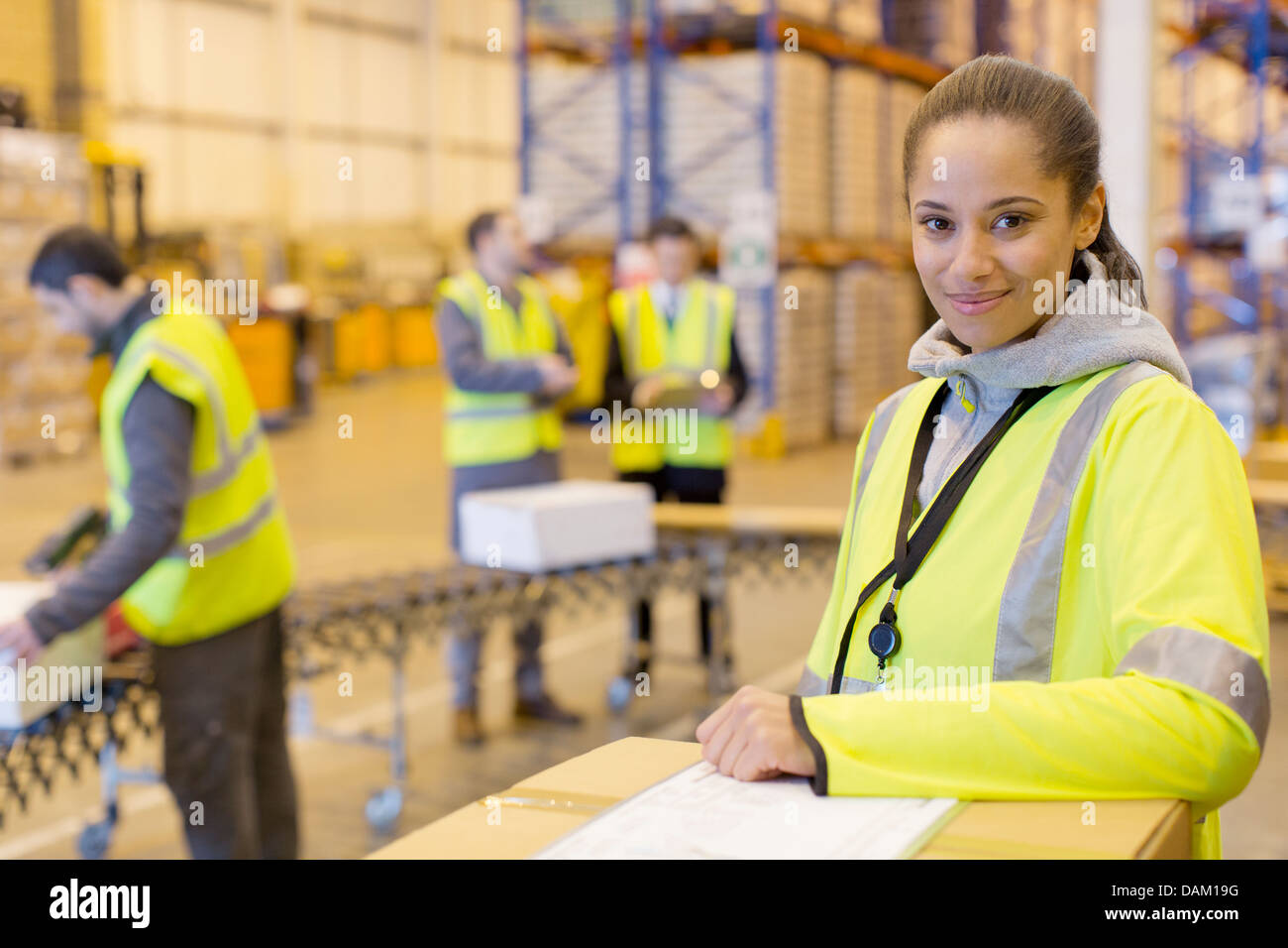 Worker smiling in warehouse Stock Photo - Alamy