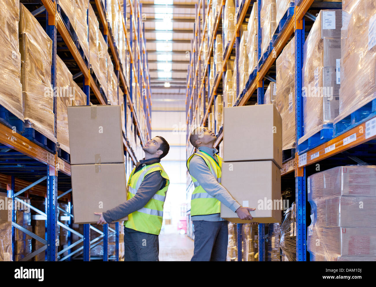 Workers carrying boxes in warehouse Stock Photo - Alamy