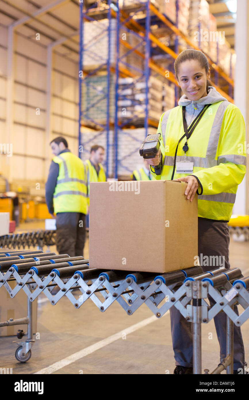 Worker scanning box on conveyor belt in warehouse Stock Photo - Alamy