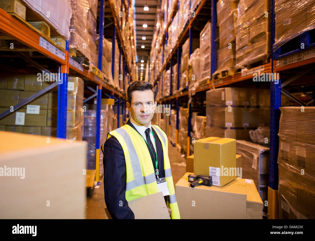 Businessman standing in warehouse Stock Photo - Alamy