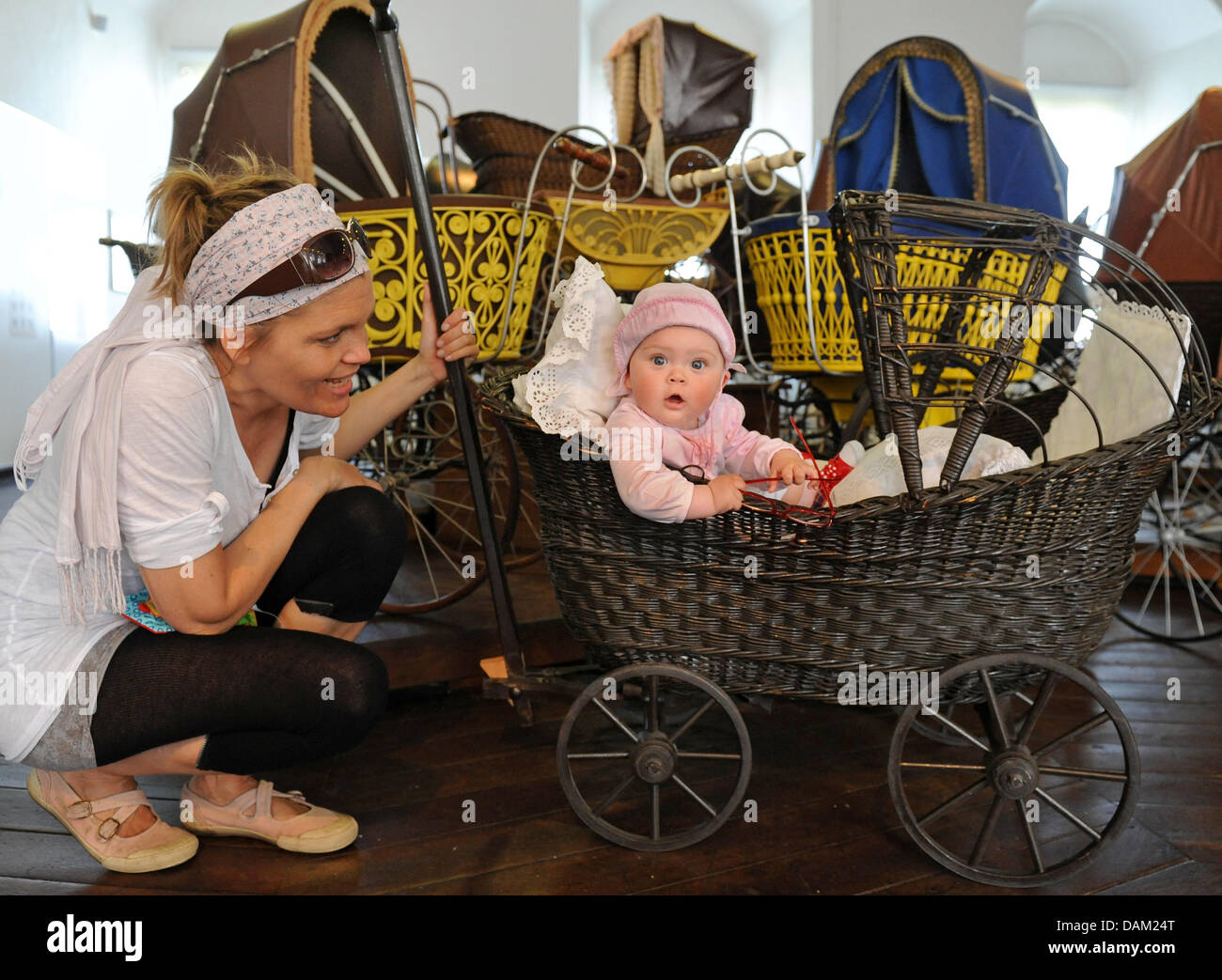 A eight-months-old baby sits inside the exhibition's oldest stroller ...