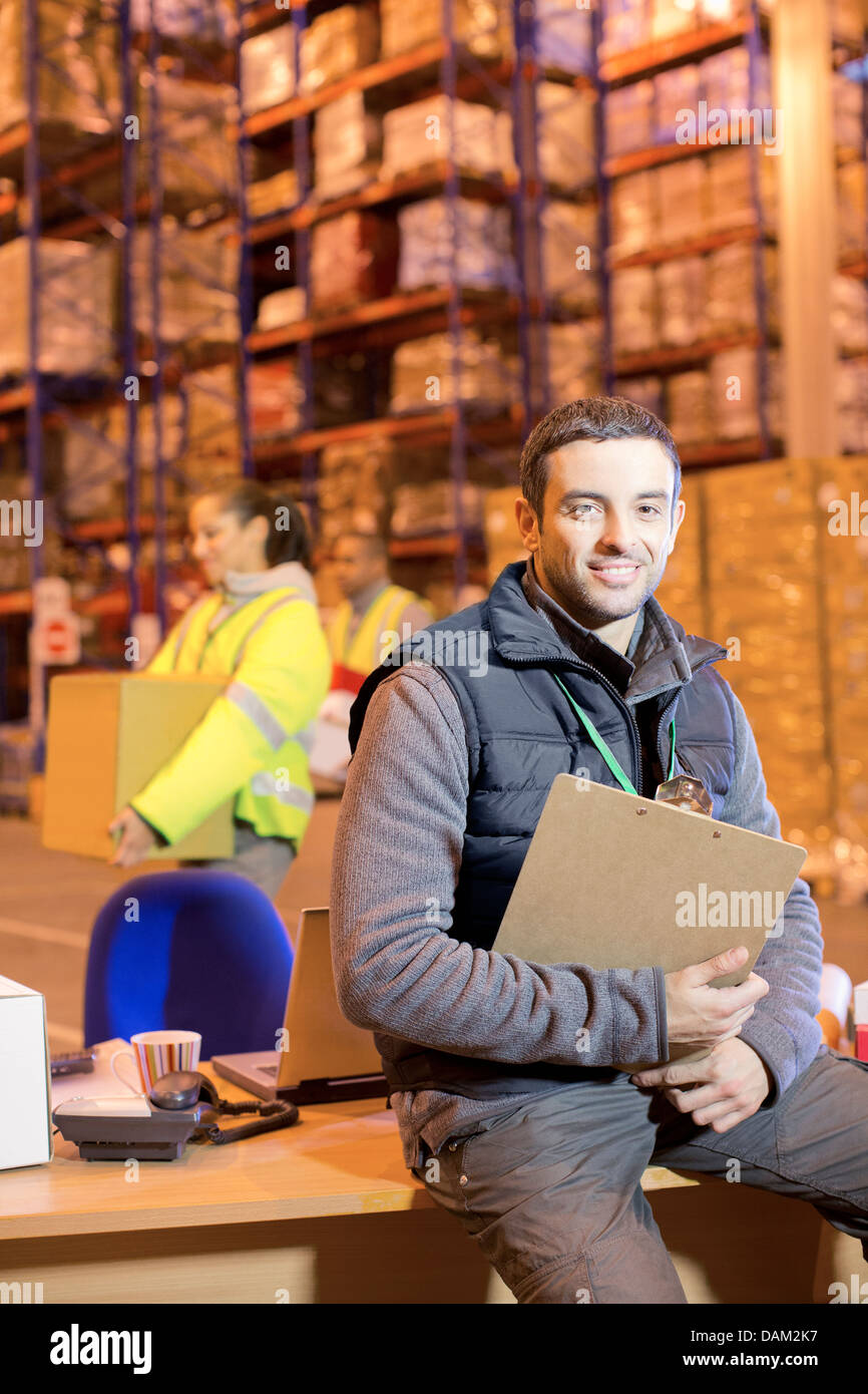 Worker smiling in warehouse Stock Photo - Alamy