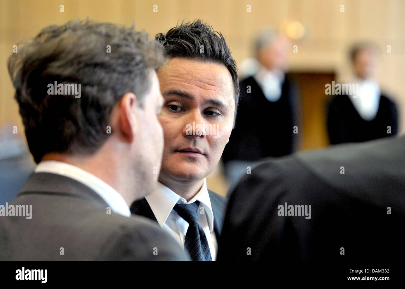 Defendant Ante Sapina (R), accused of organized fraud, talks to his ...