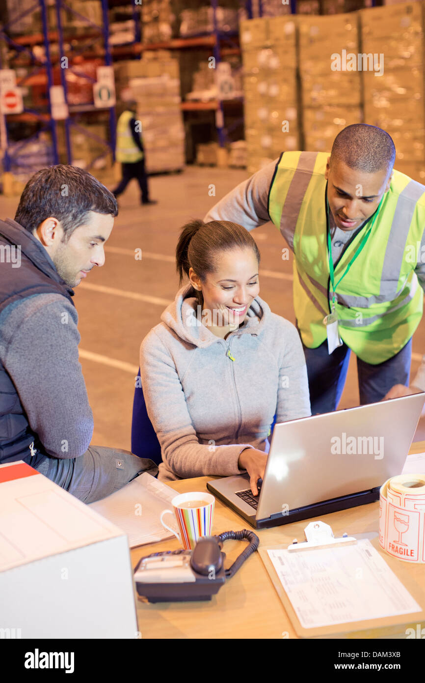 Workers using laptop in warehouse Stock Photo - Alamy