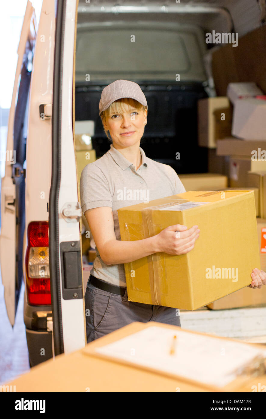 Delivery girl unloading boxes from van Stock Photo - Alamy