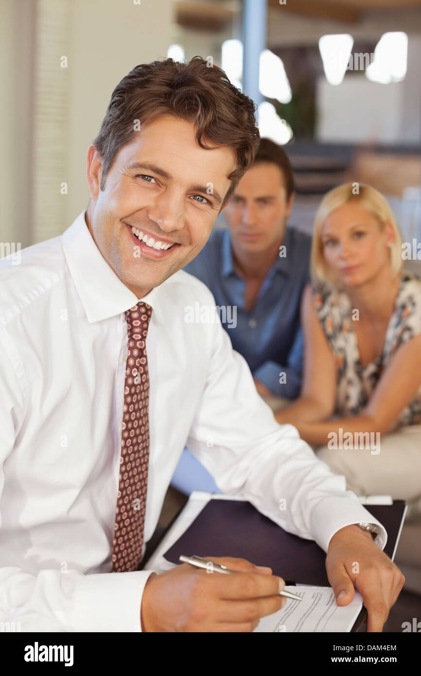 Smiling couple sitting on the couch using tablet pc and watching tv at ...