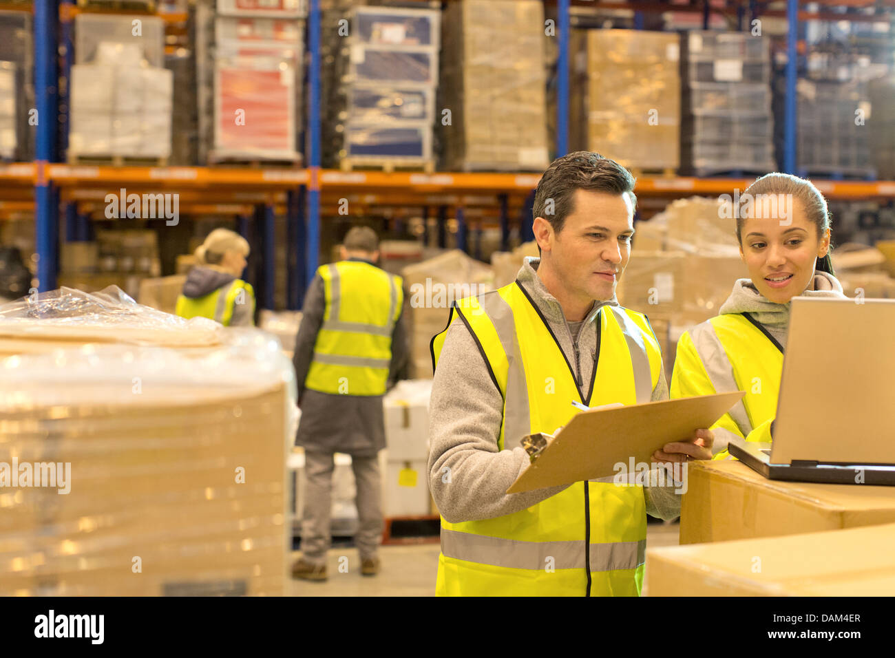 Workers using laptop in warehouse Stock Photo - Alamy