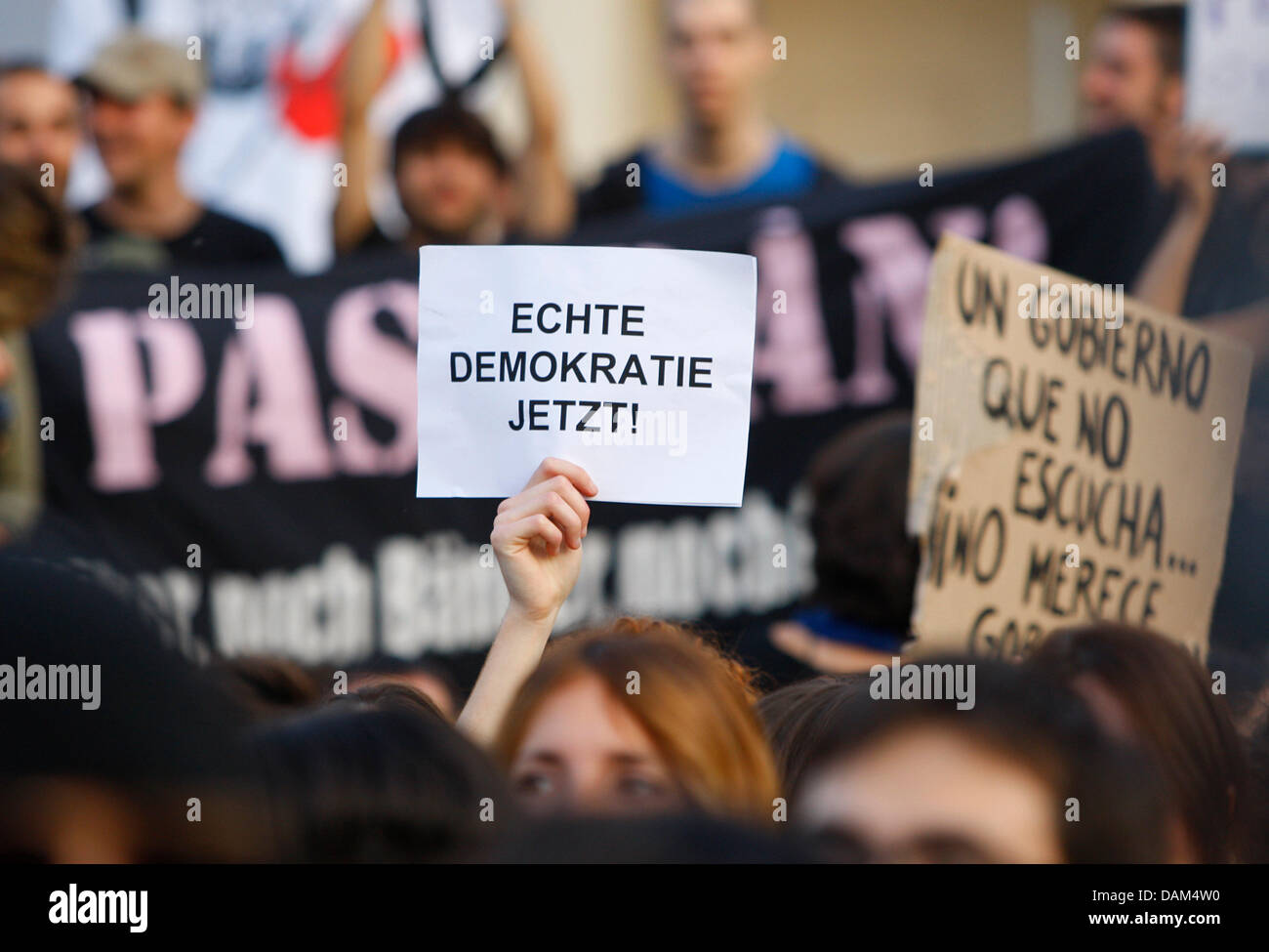 A woman holds a sign 'Real Democracy Now' ('Echte Demokratie Jetzt') at ...