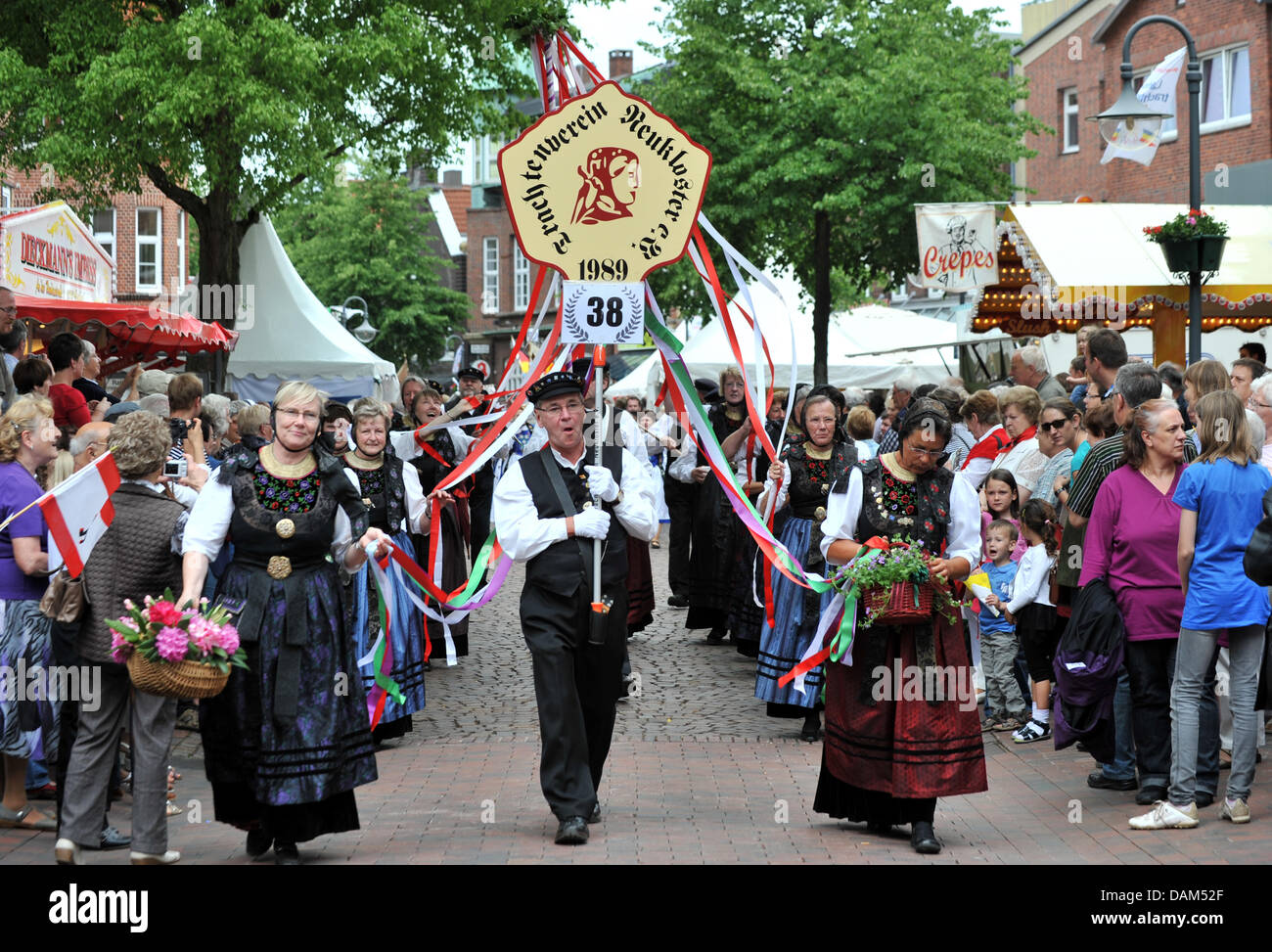 Members of the folklore group Neukloster walk the streets in ...