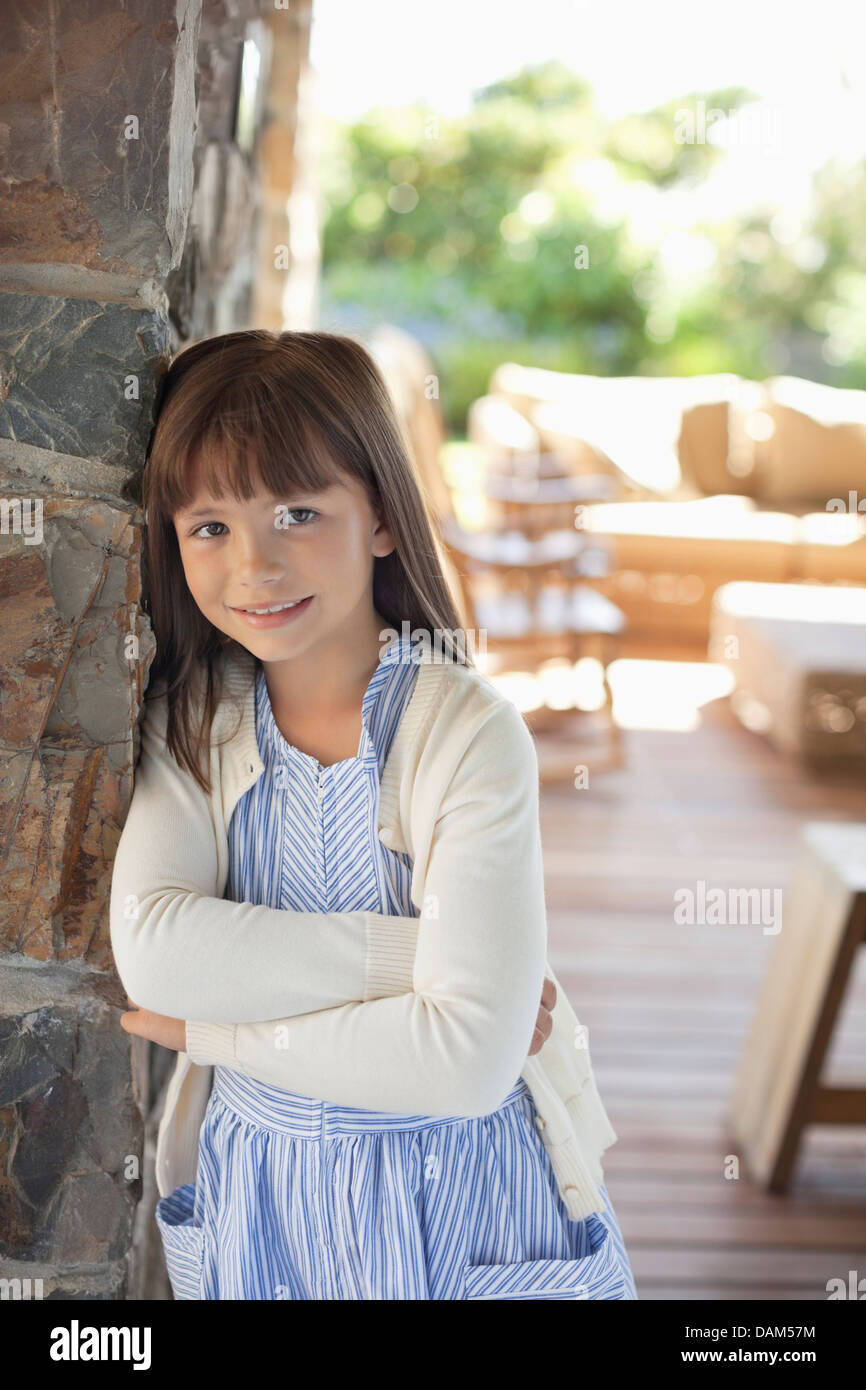 Girl leaning against stone wall Stock Photo - Alamy