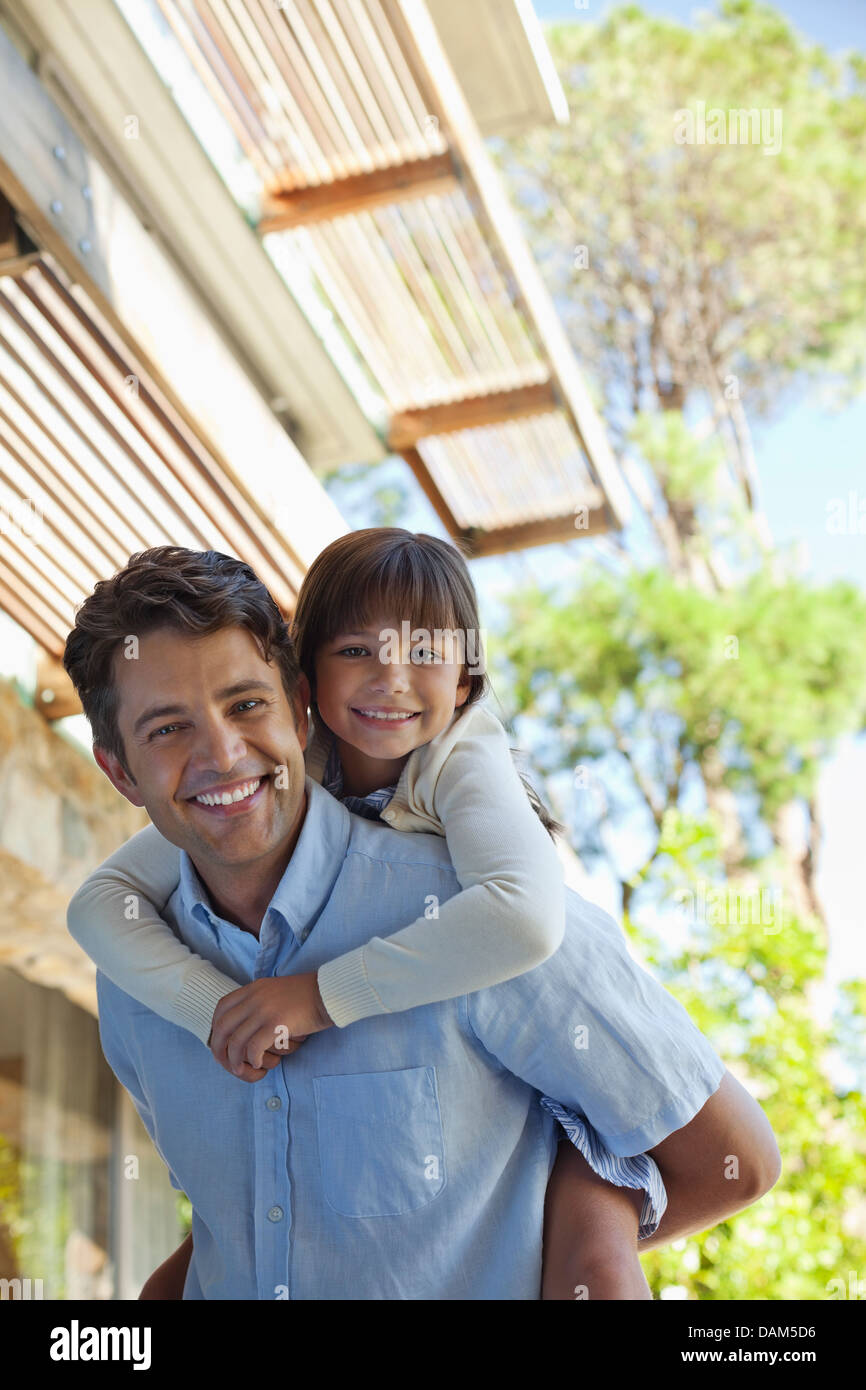 Father carrying daughter piggy back outdoors Stock Photo - Alamy