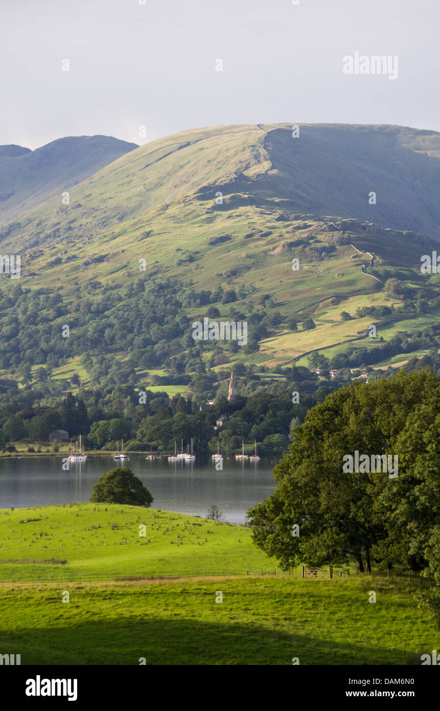 A view of green field on a shore of Windermere and Wansfell in the ...
