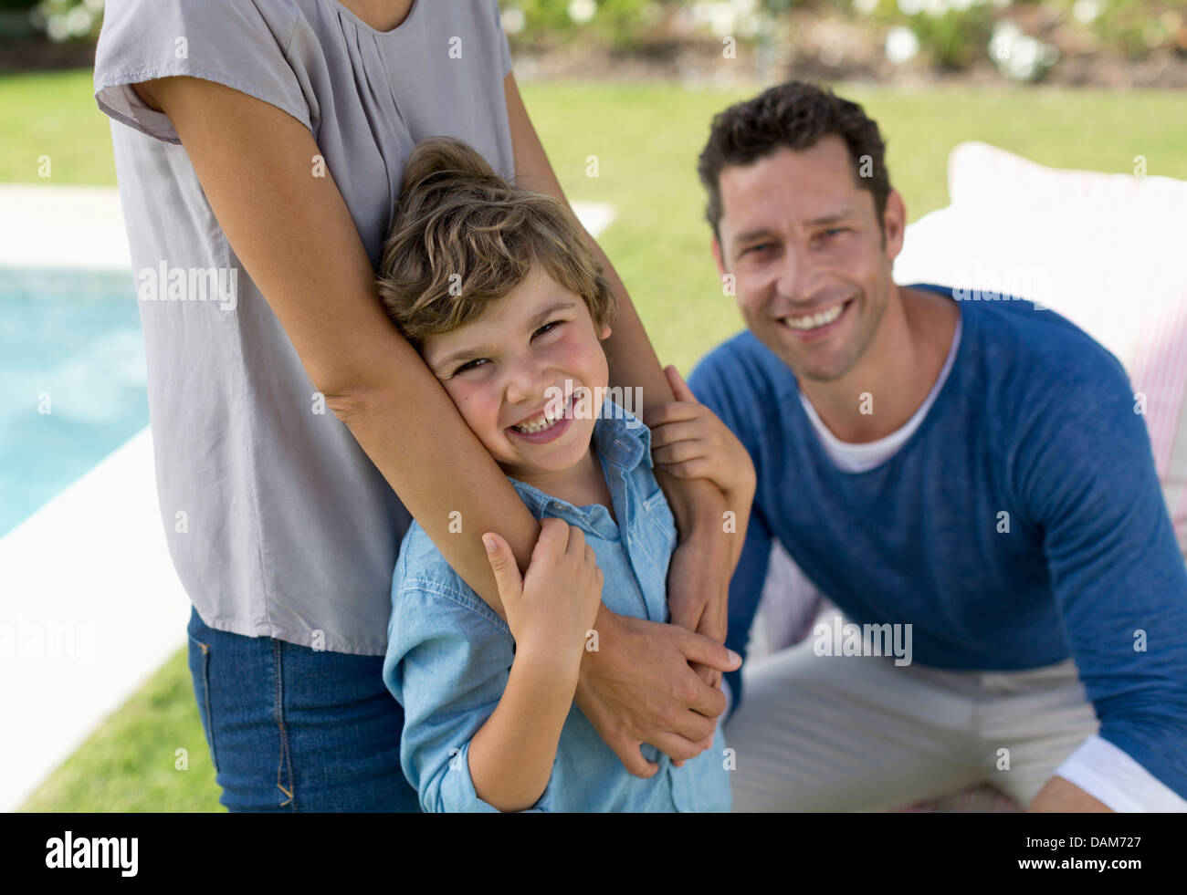 Family smiling in backyard Stock Photo - Alamy