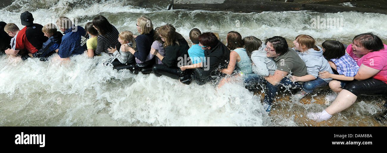 A timber rafter guides his raft full of people through a dam on the ...