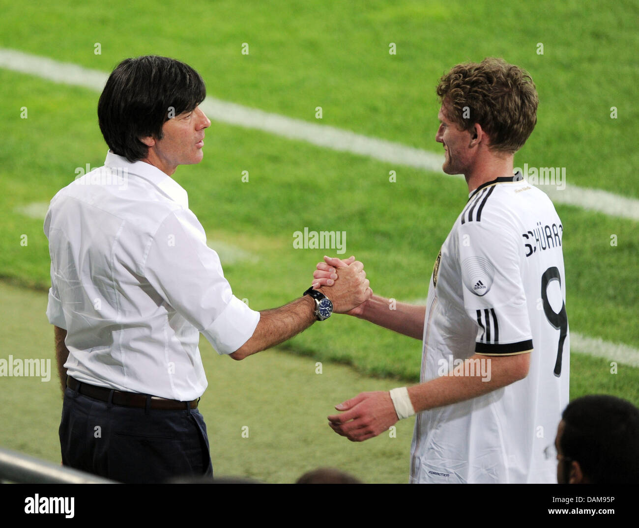 Germany's Coach Joachim Loew (L) shakes hands with Andre Schuerrle ...