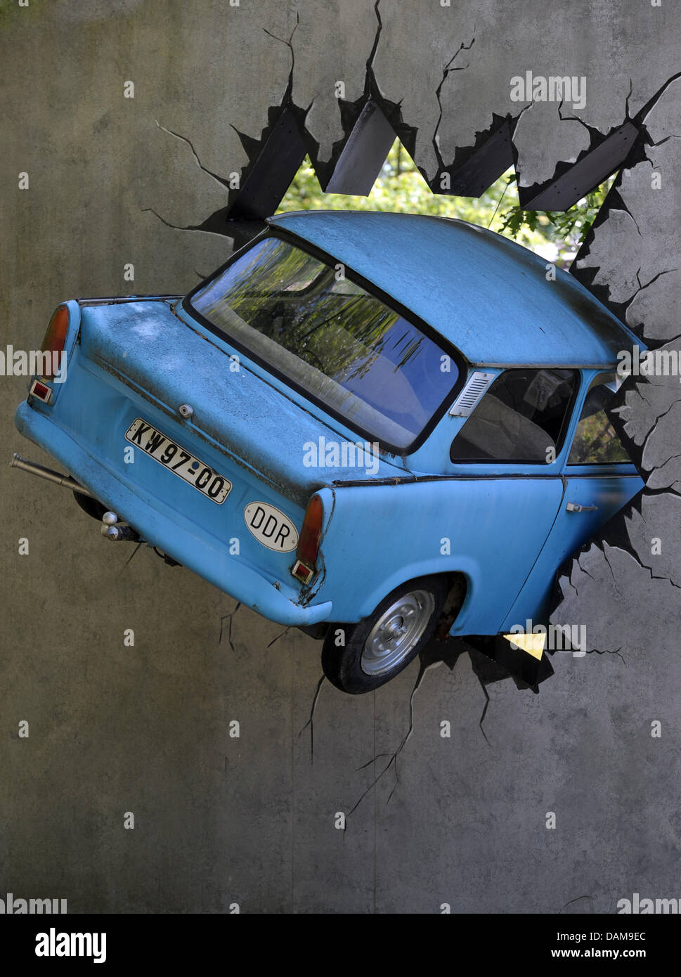 A blue Trabant from East Germany breaks through a symbolic wall at the ...