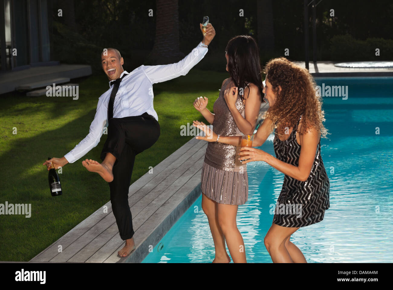 Friends playing by swimming pool Stock Photo - Alamy