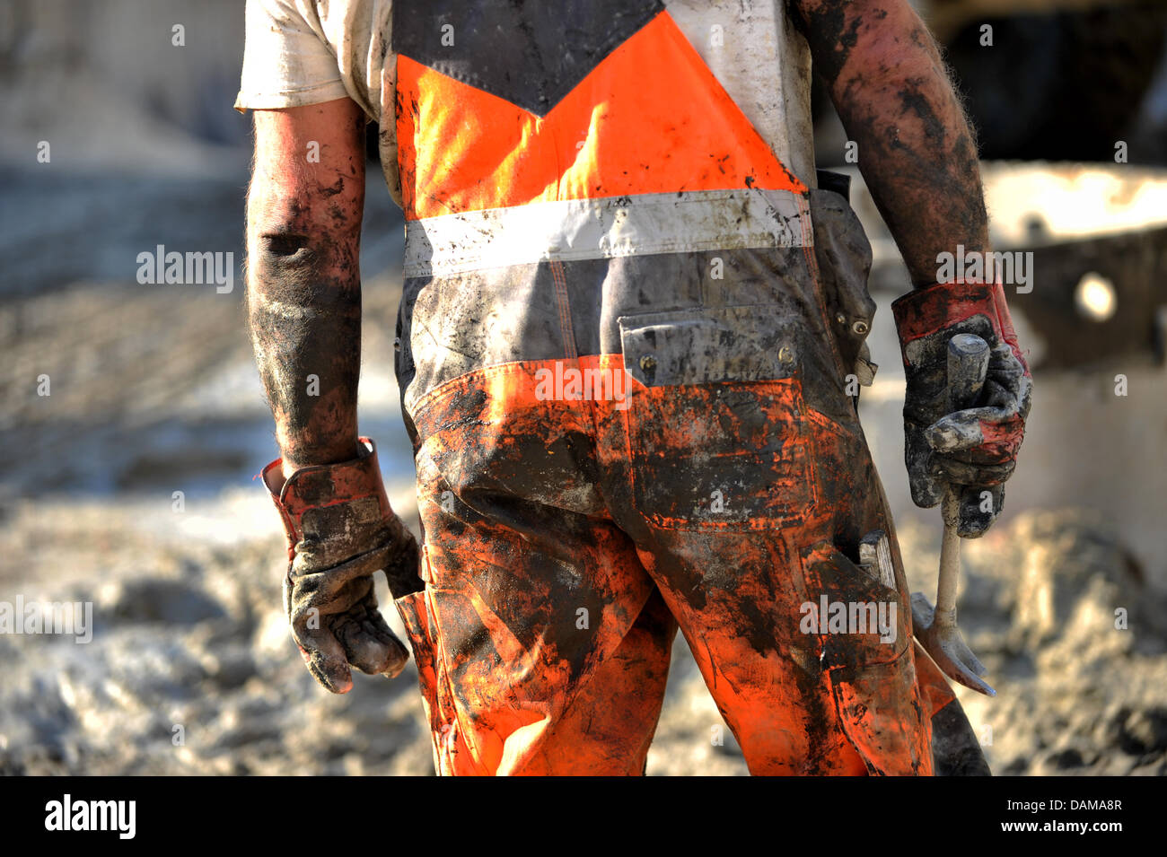 A muddy construction worker in uniform is pictured in Munich, Germany ...