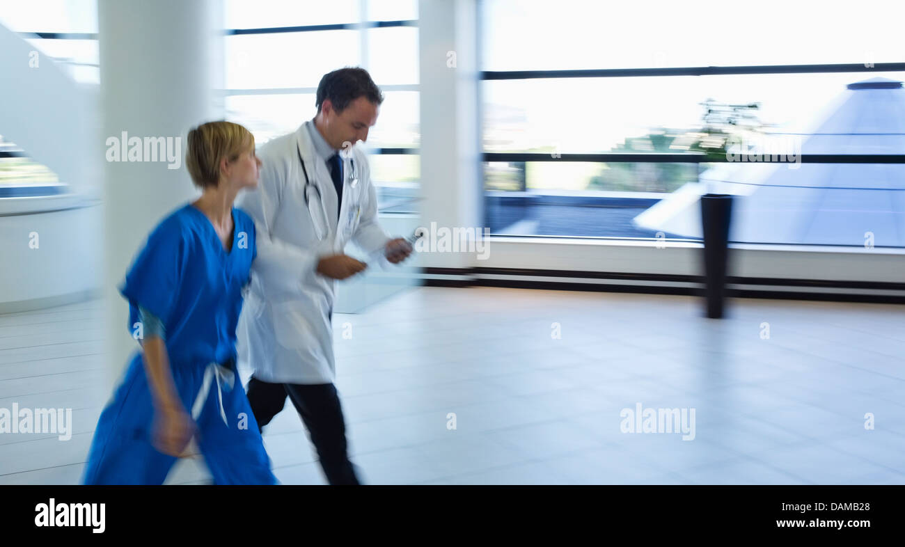 Doctor and nurse talking in hospital hallway Stock Photo - Alamy
