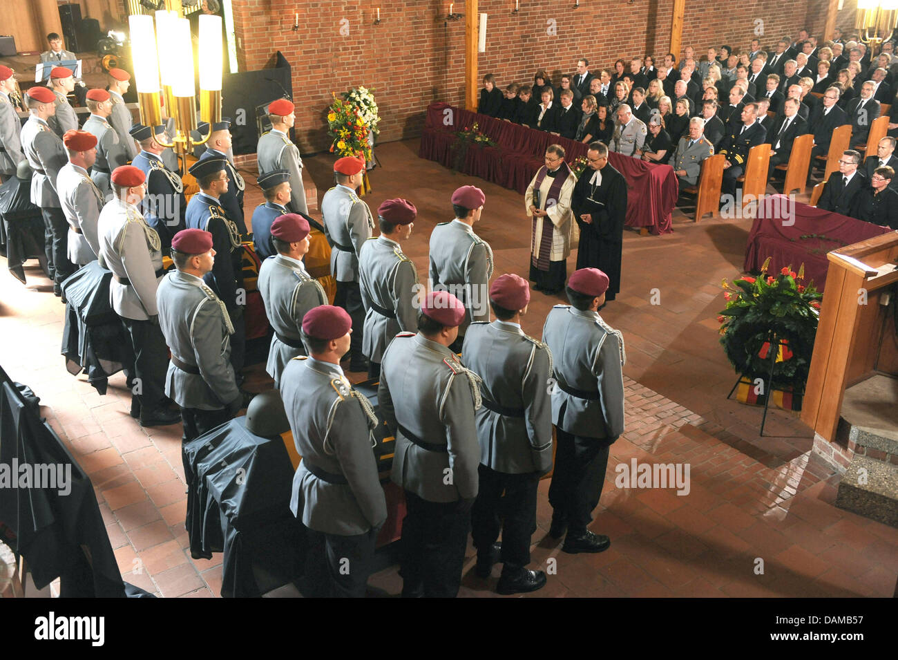 Soldiers of the German Bundeswehr stand beside coffins of three ...