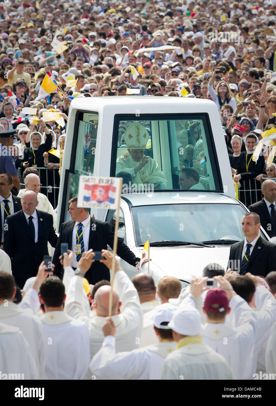 Pope Benedict XVI is driven through the crowd in his Popemobile prior ...