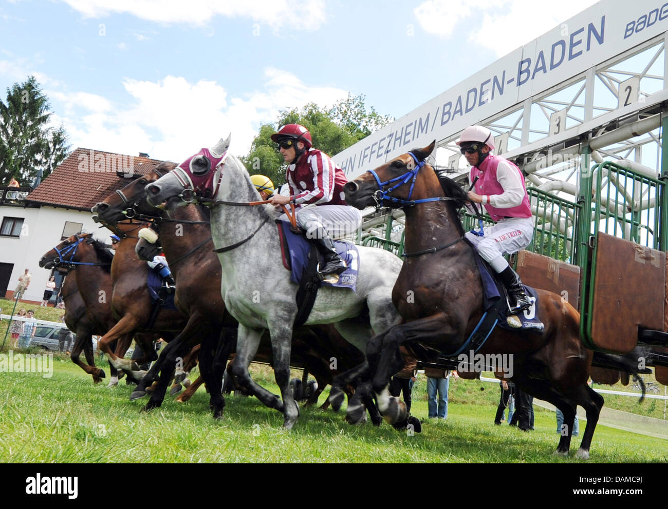A group of horse riders start a race at the horse race track Iffezheim ...