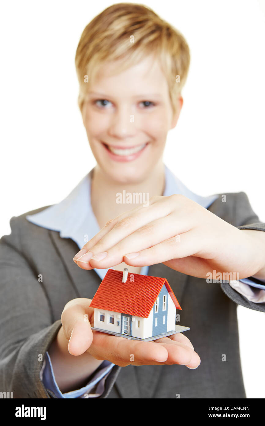 Young happy woman holding her protecting hand over a little house Stock ...