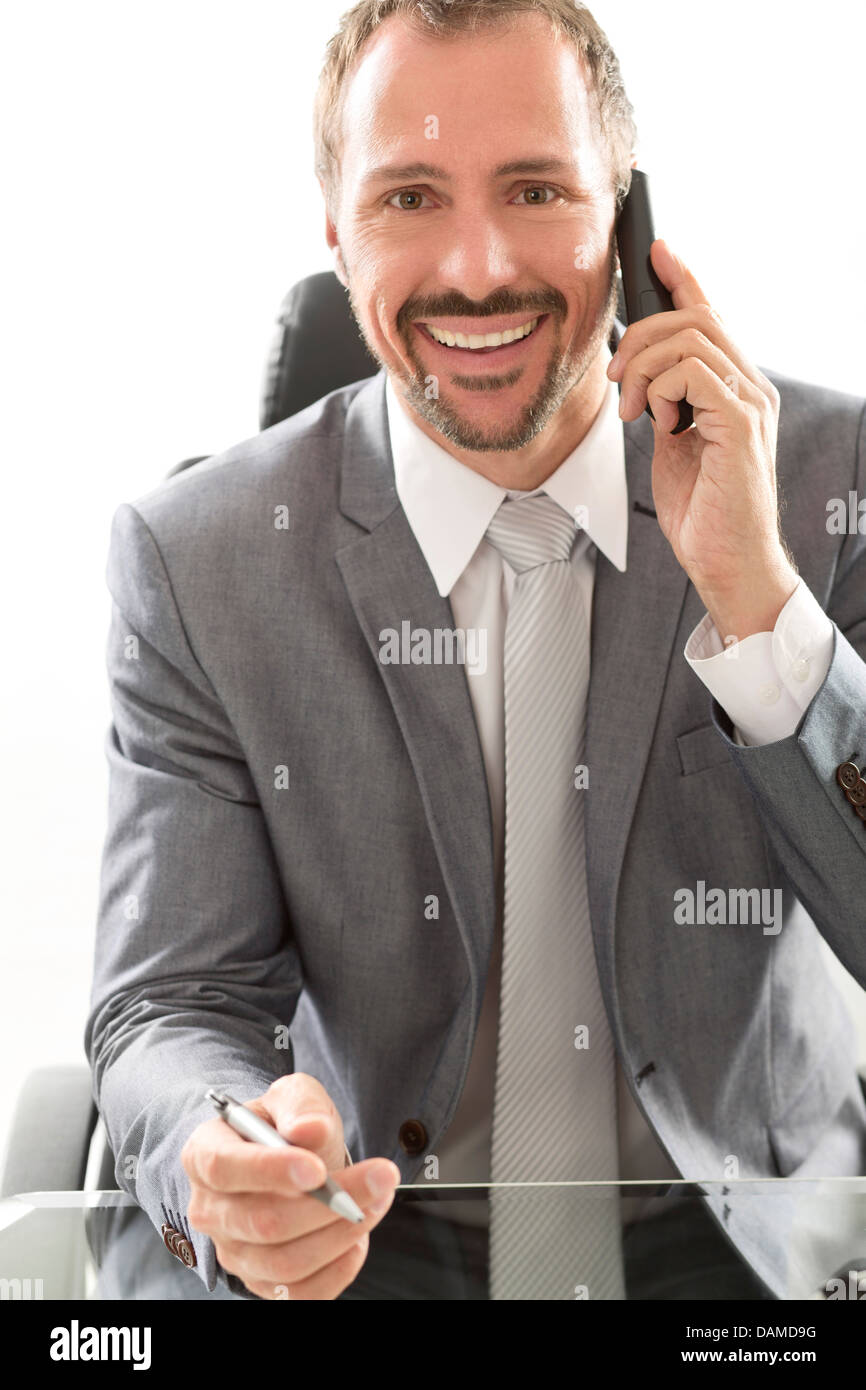 Germany, Portrait of businessman talking on mobile phone, smiling Stock ...