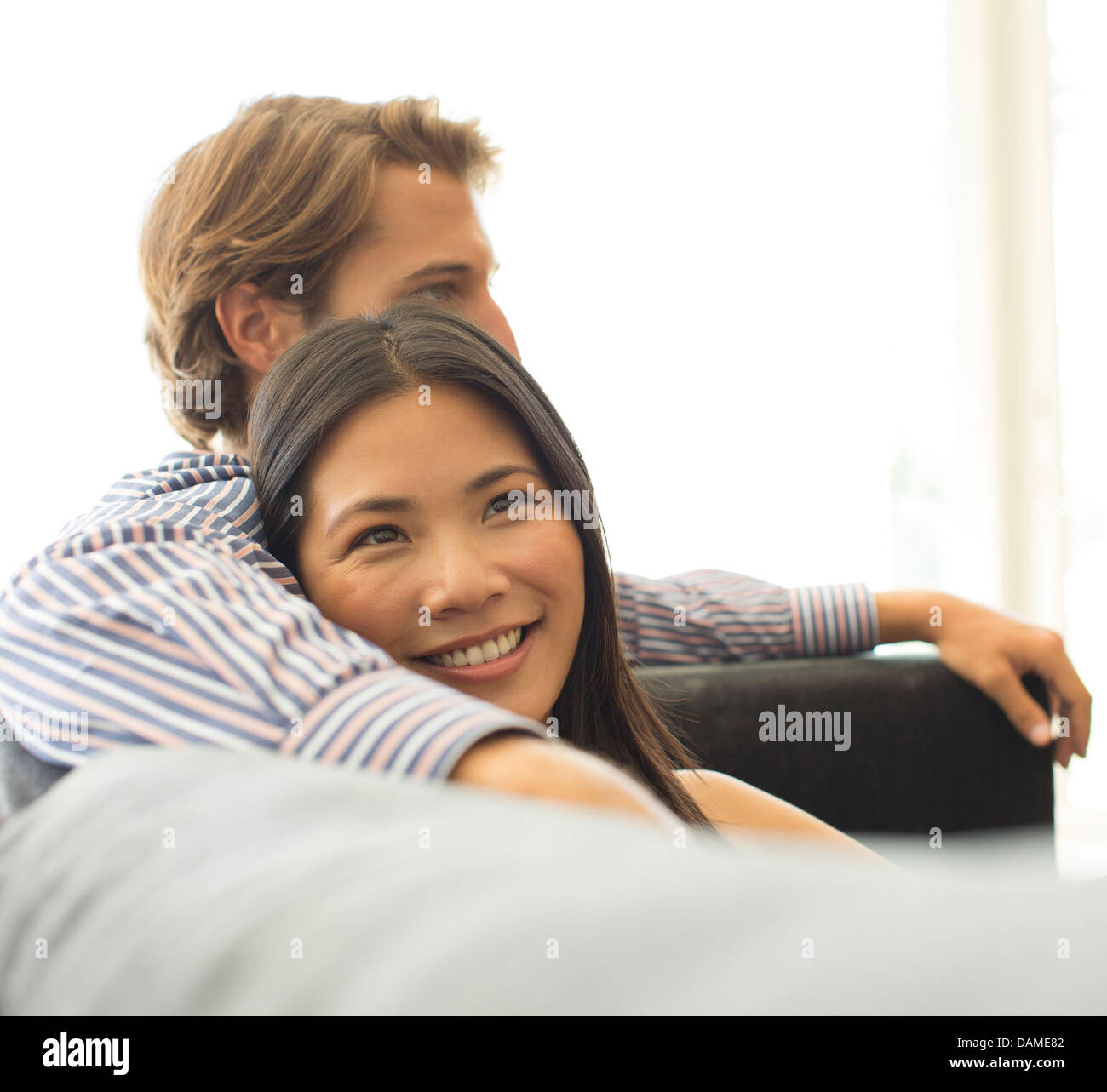 Young Couple Cuddling On Sofa High Resolution Stock Photography and ...
