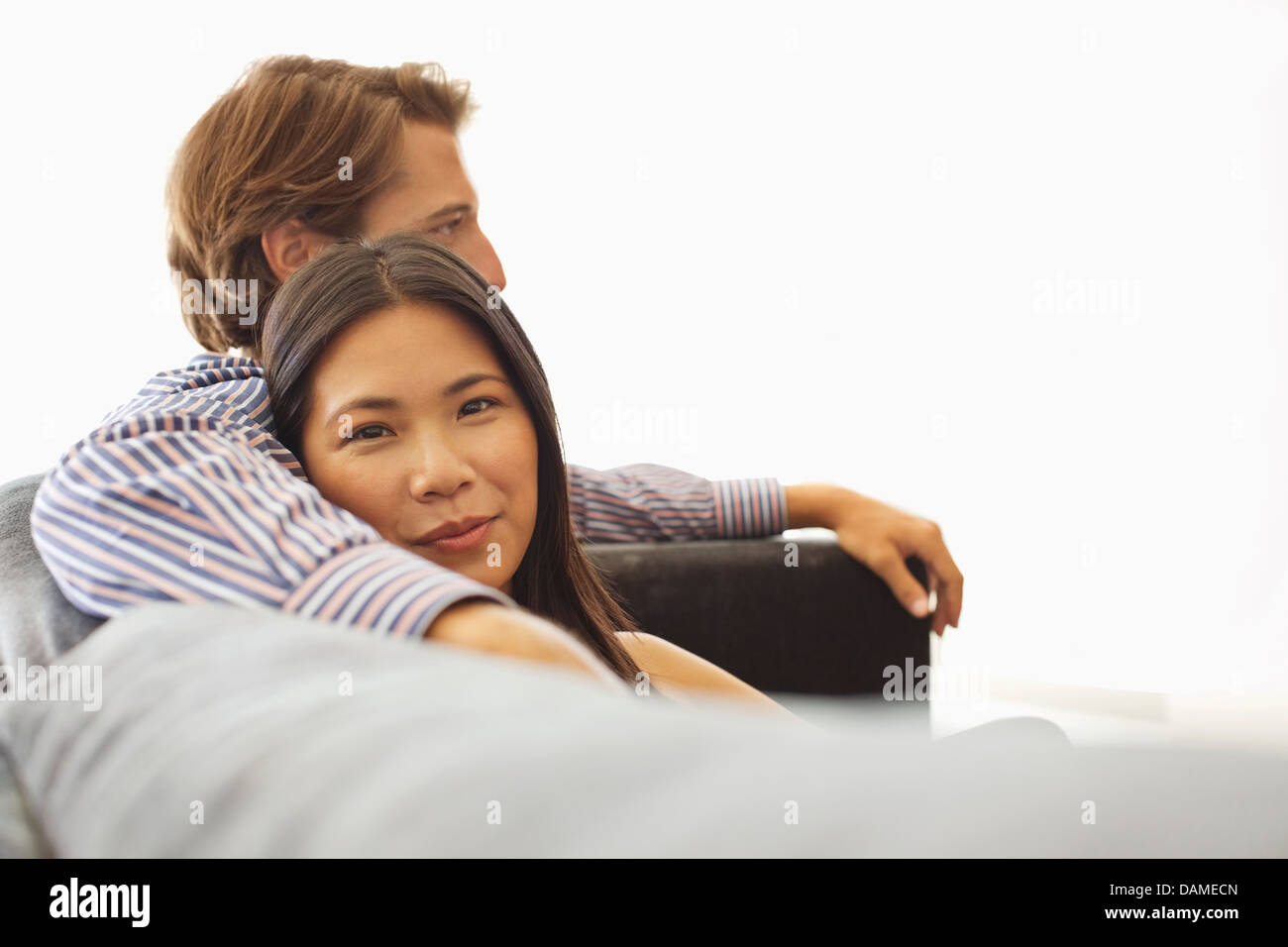 Smiling couple relaxing on sofa Stock Photo - Alamy